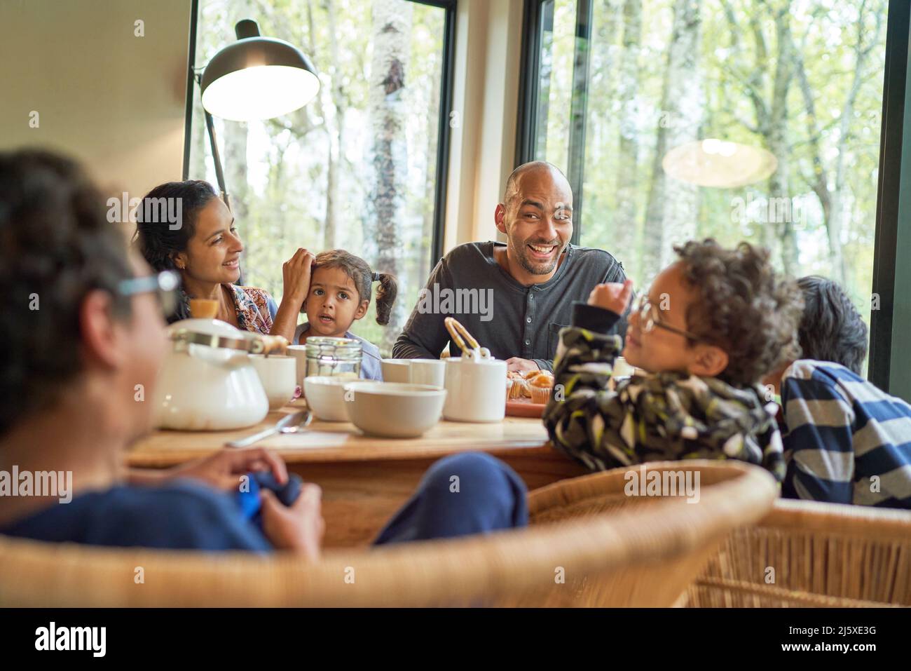 Happy family eating at dining table Stock Photo - Alamy