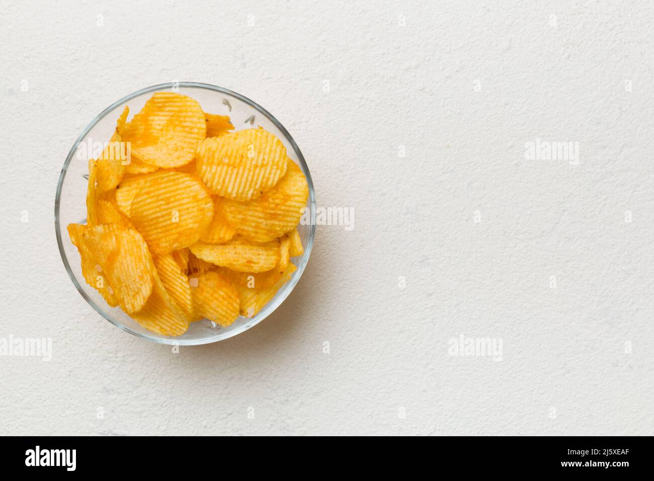 Potato chips on bowl isolated on colored background. Delicious crispy ...