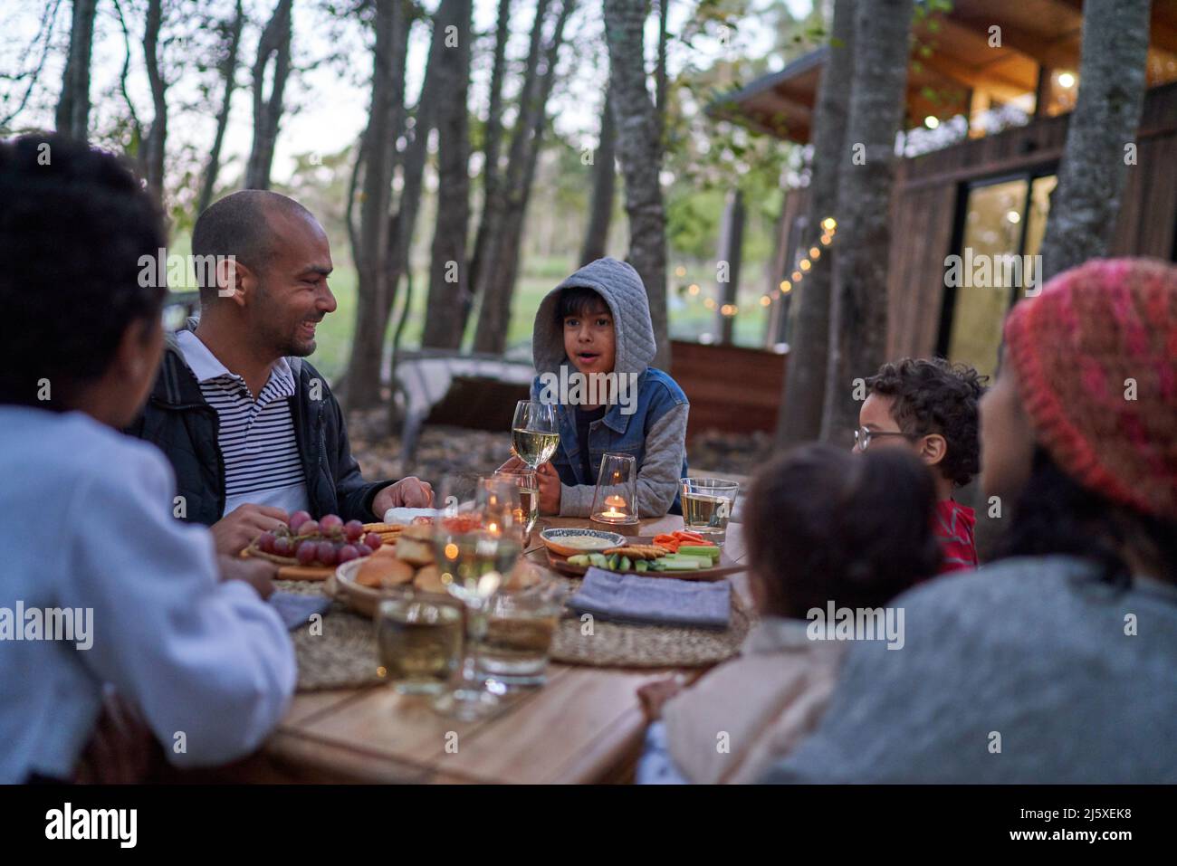 Family eating at table outside cabin in woods Stock Photo - Alamy