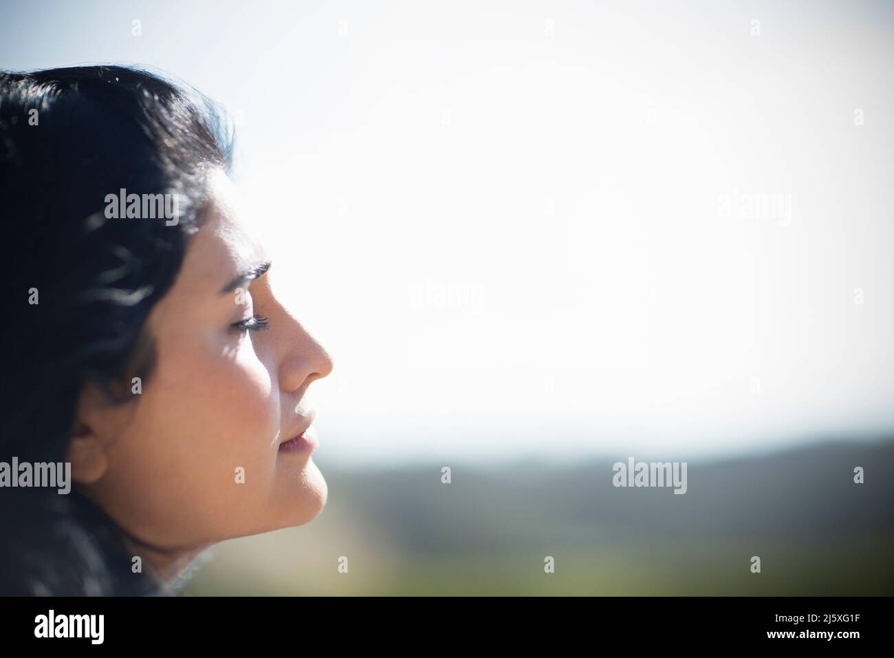 Profile serene young woman basking in sunlight with eyes closed Stock ...