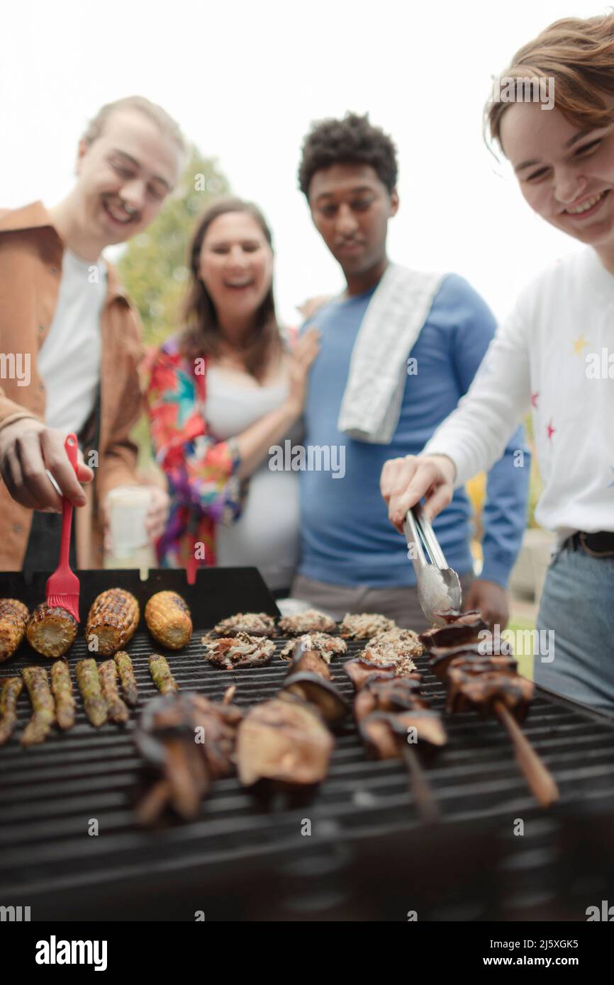 Happy friends barbecuing vegetables at barbecue grill Stock Photo - Alamy
