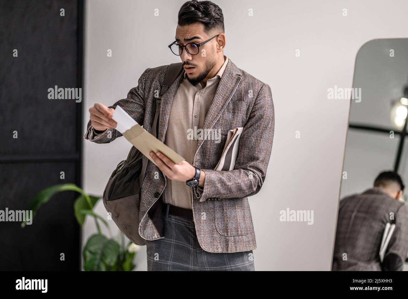 A young man in stylish jacket reading papers Stock Photo - Alamy
