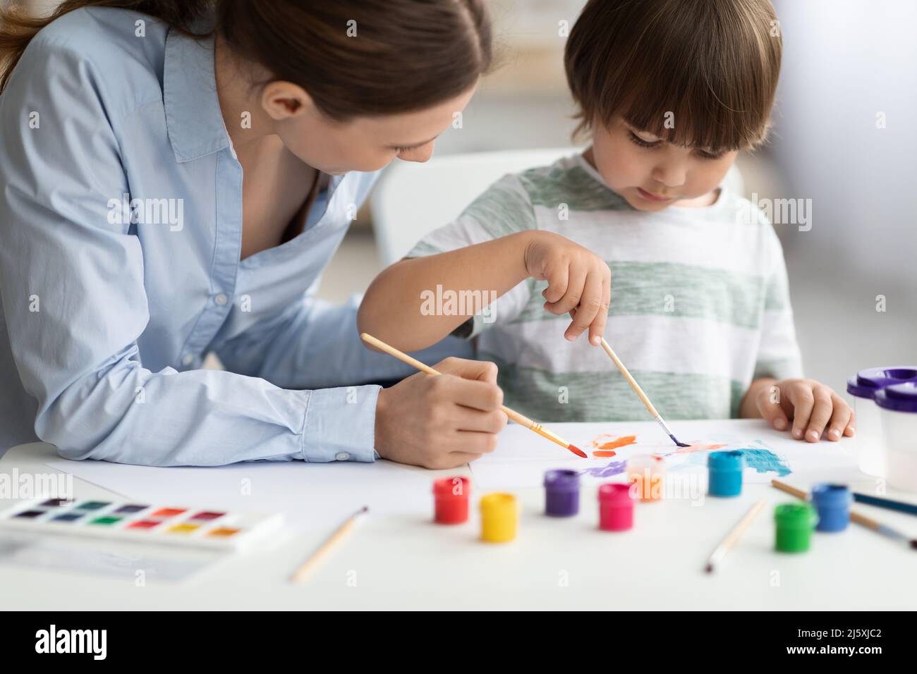 Art classes for preschoolers. Professional woman tutor helping little ...