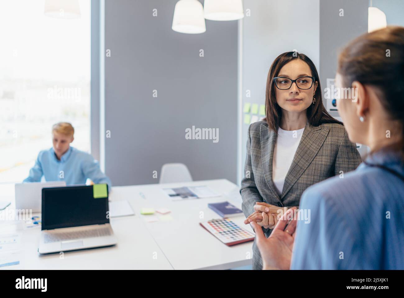 Business women standing in the office and talking Stock Photo - Alamy