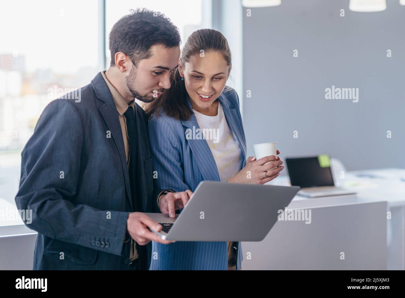 Employees in the office with a laptop Stock Photo - Alamy