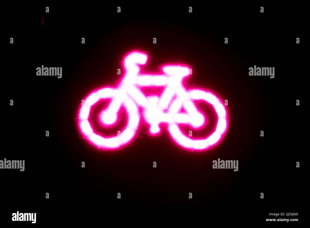 The traffic light of a bicycle-shaped bike lane, in red, illuminated at ...