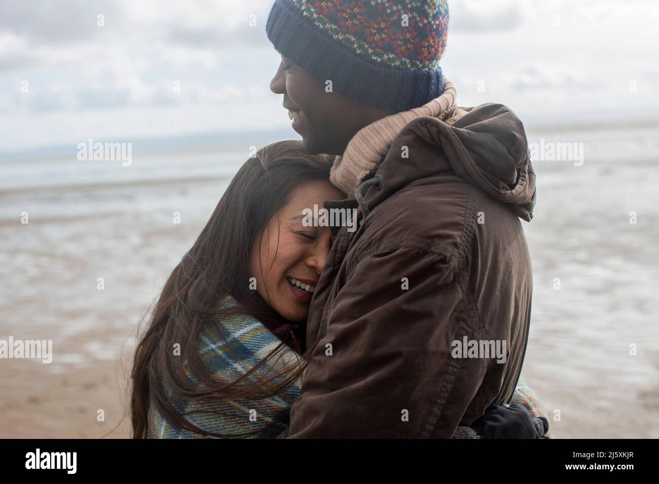 Happy affectionate couple hugging on winter beach Stock Photo - Alamy