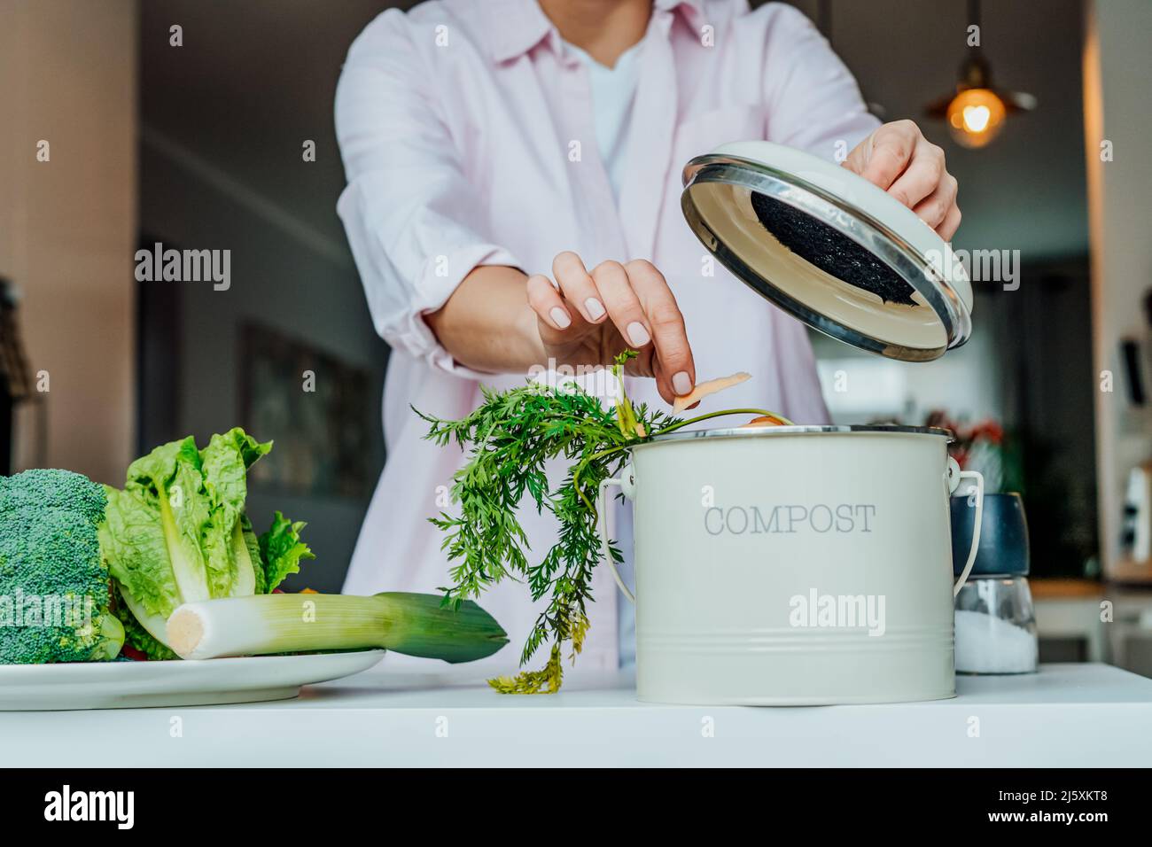 Compost the kitchen waste, recycling at home. Woman putting vegetables ...