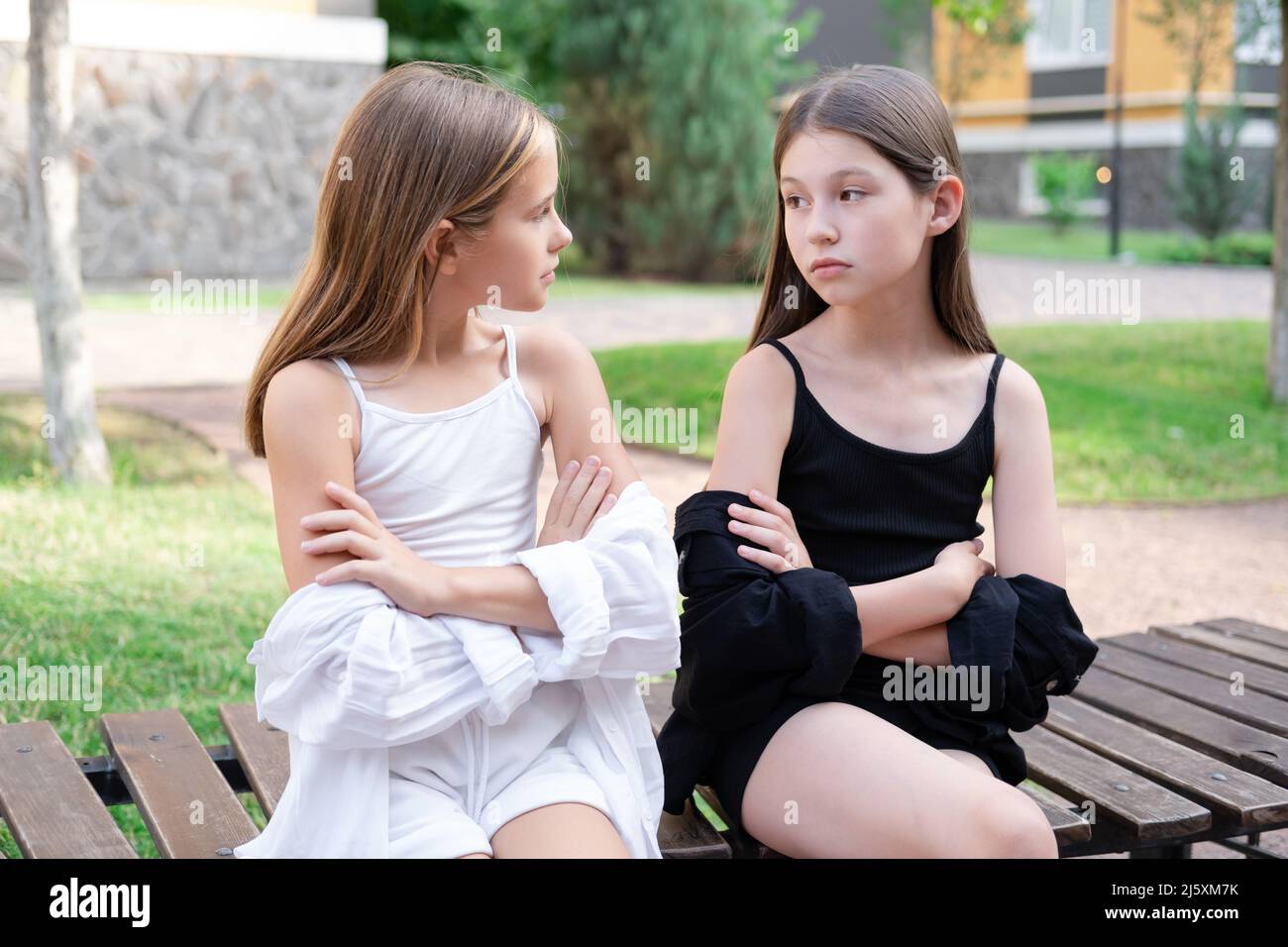 fraternal twins sisters. blonde and brunette teen girls in fashionable ...