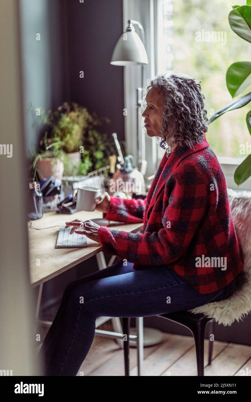 Senior woman desk working in hi-res stock photography and images - Alamy
