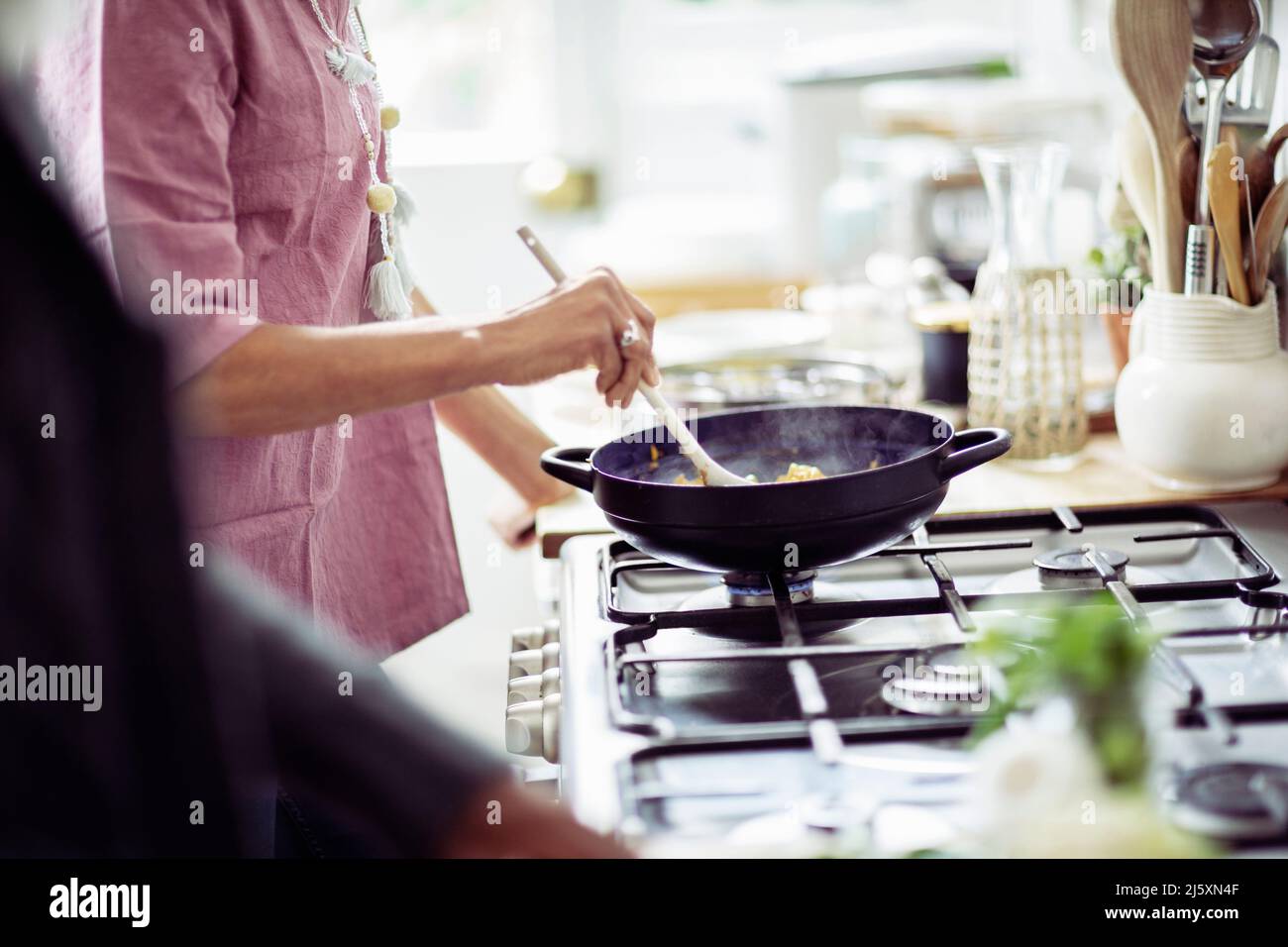 Woman cooking at stove hi-res stock photography and images - Alamy