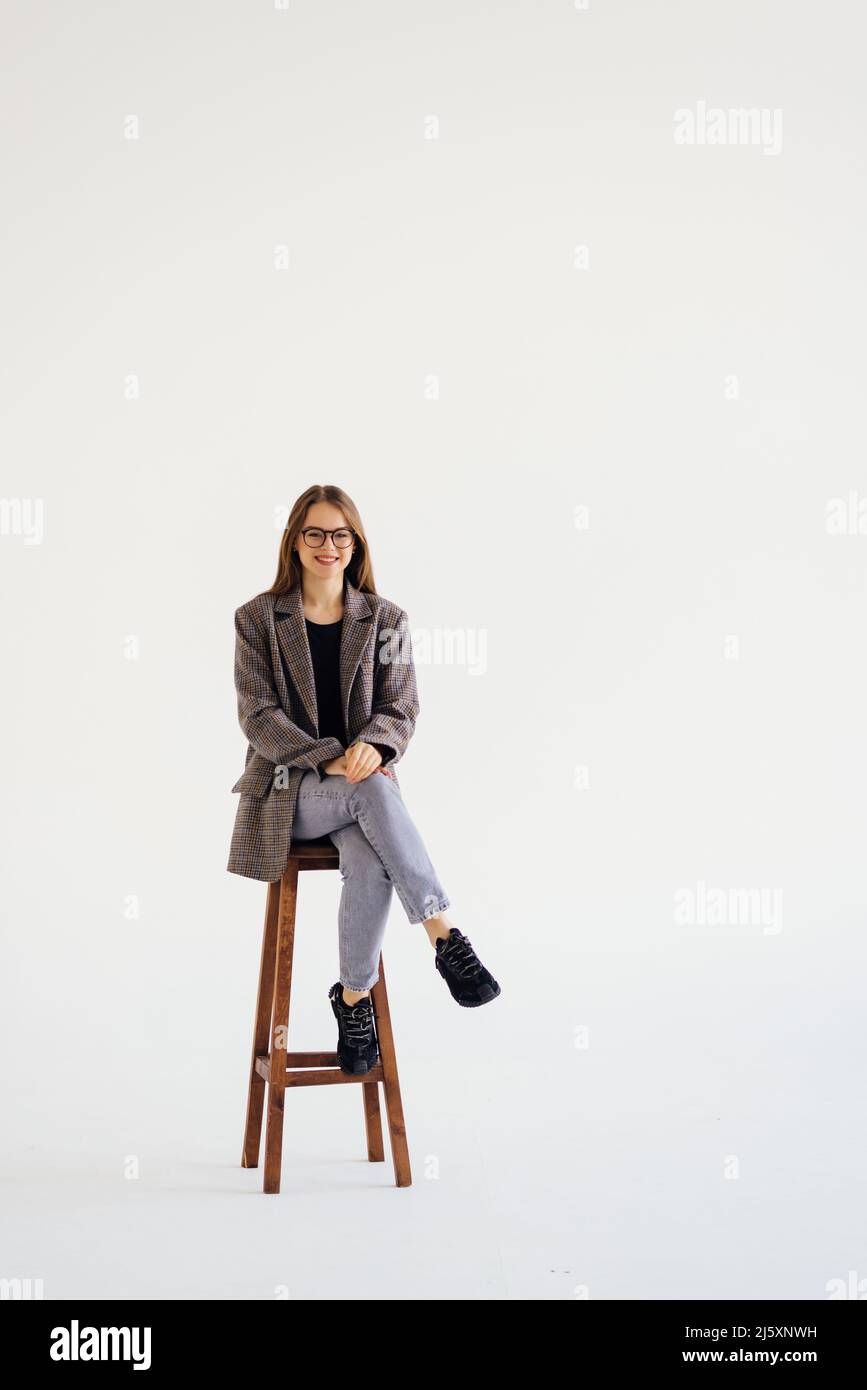 Full length image of happy business woman in formal wear sitting on ...