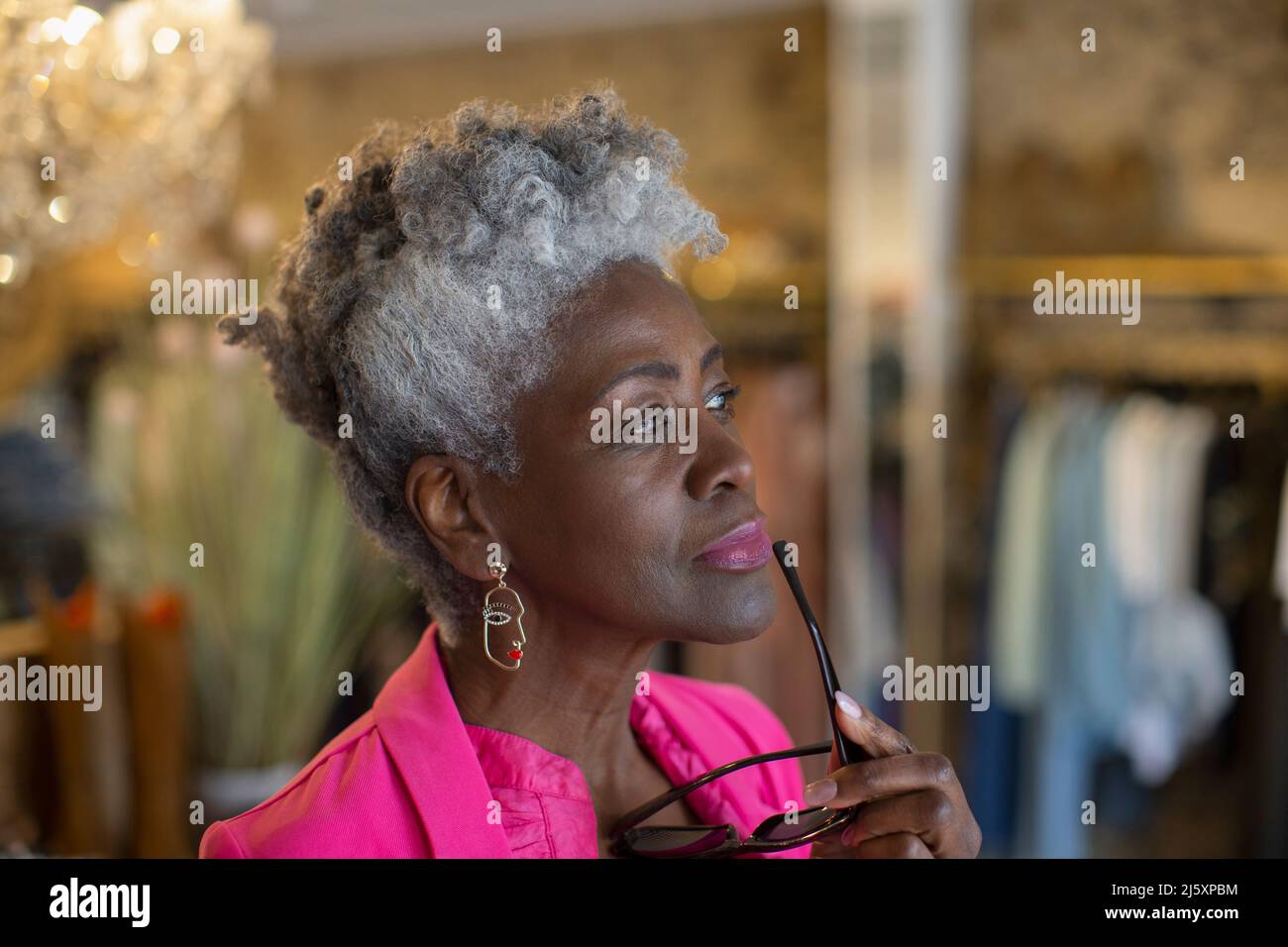 Thoughtful senior shop owner looking away Stock Photo - Alamy