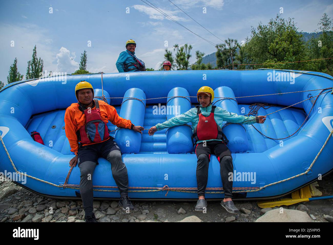 Indian tourists are seen resting on a boat after rafting in a Lidder ...