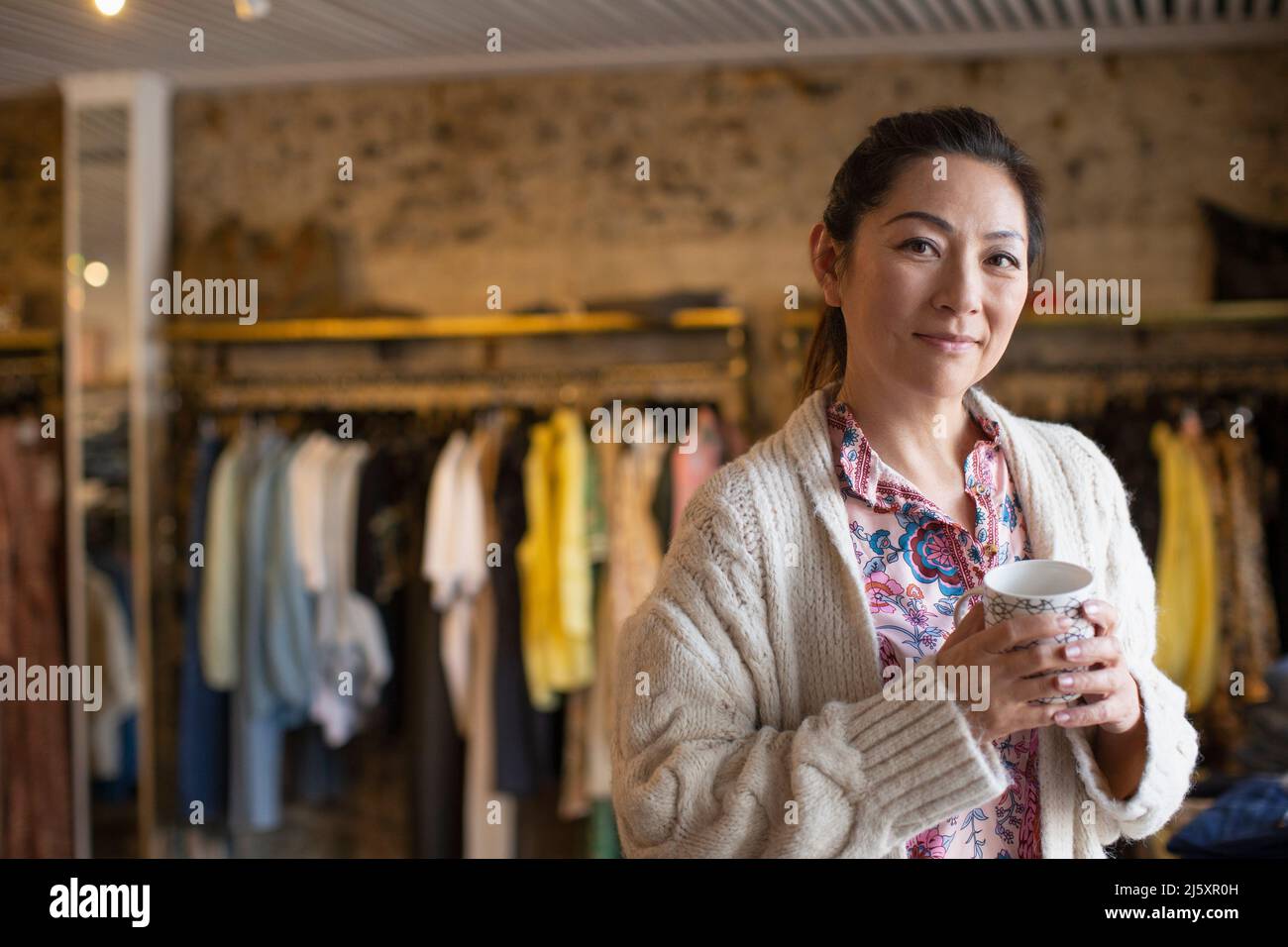 Portrait confident female shop owner with tea in boutique Stock Photo ...