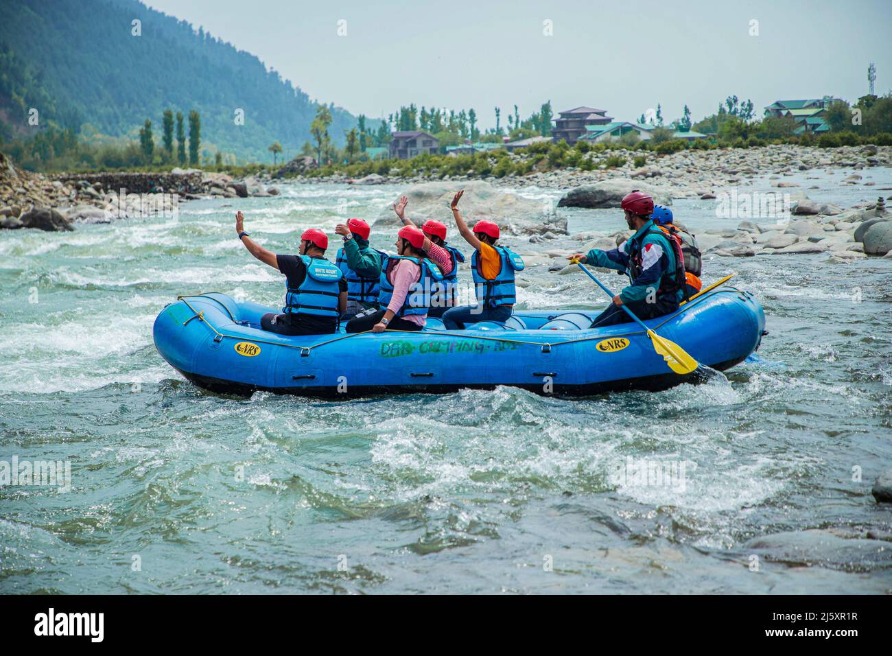 Indian tourists gestures to their family while rafting in a Lidder ...
