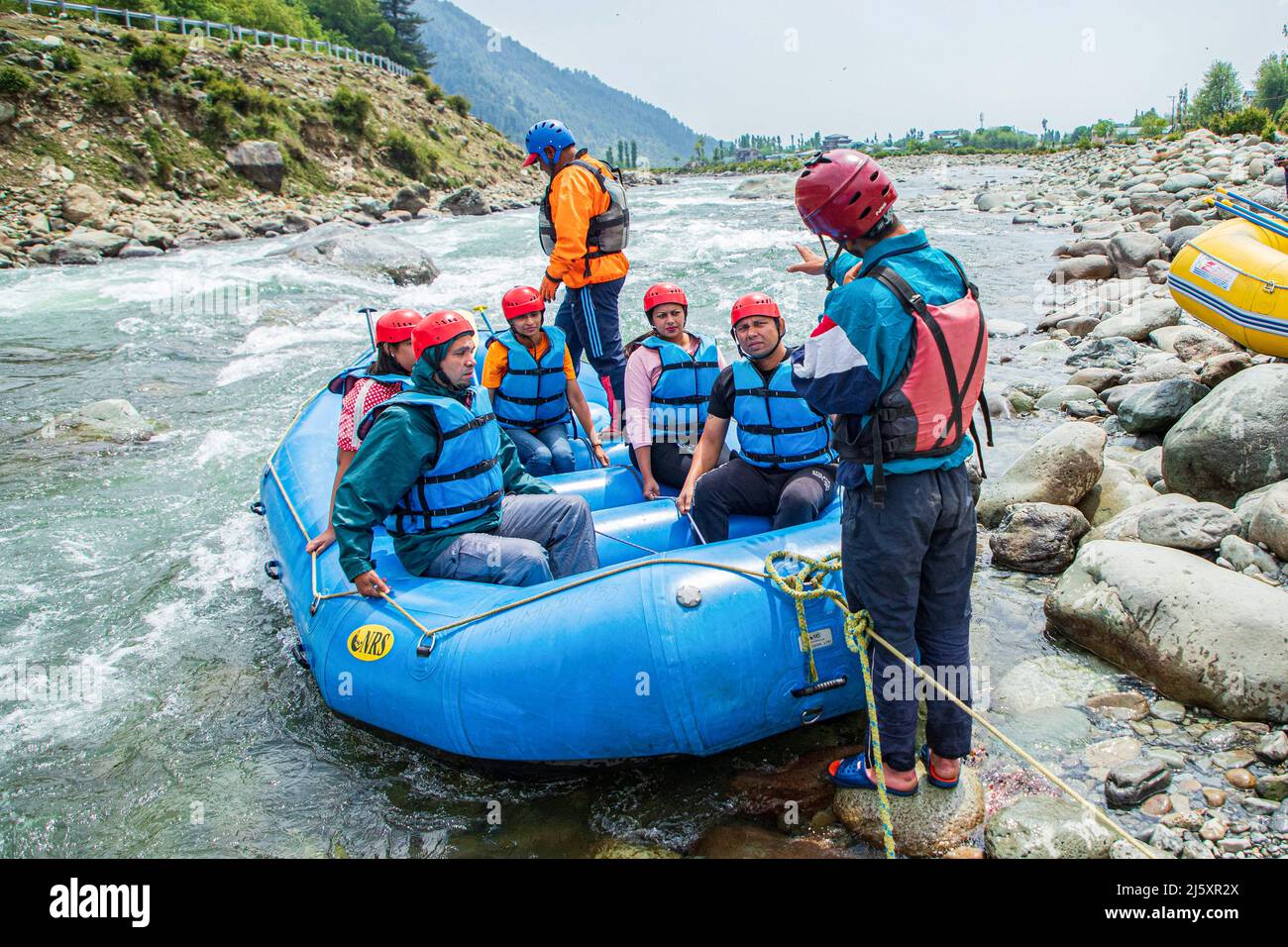Indian tourists receive instructions from a raft guide before rafting ...