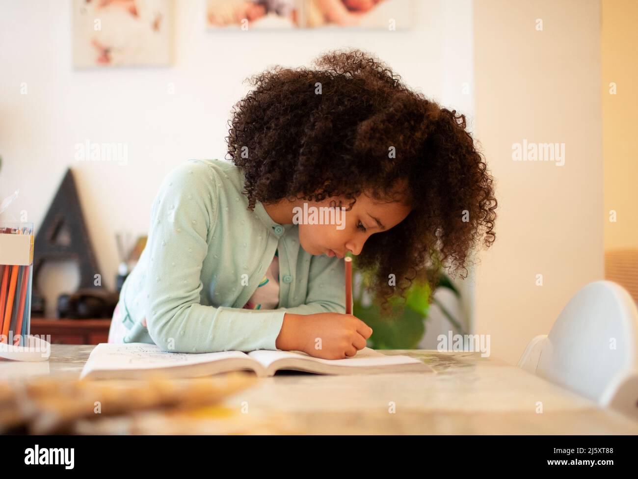 Focused girl coloring in coloring book Stock Photo - Alamy