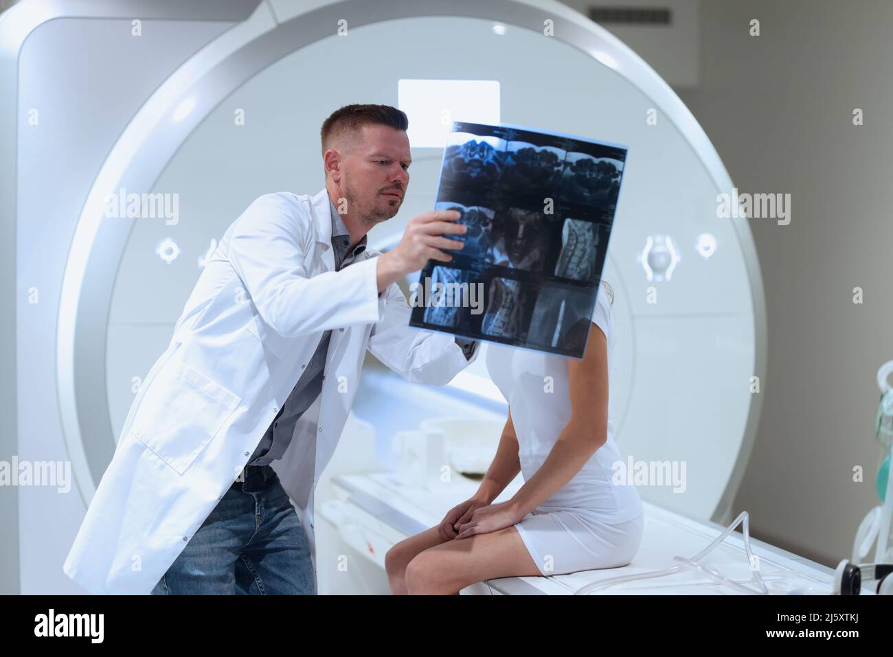 Doctor showing patient mri scan of spine in clinic Stock Photo - Alamy