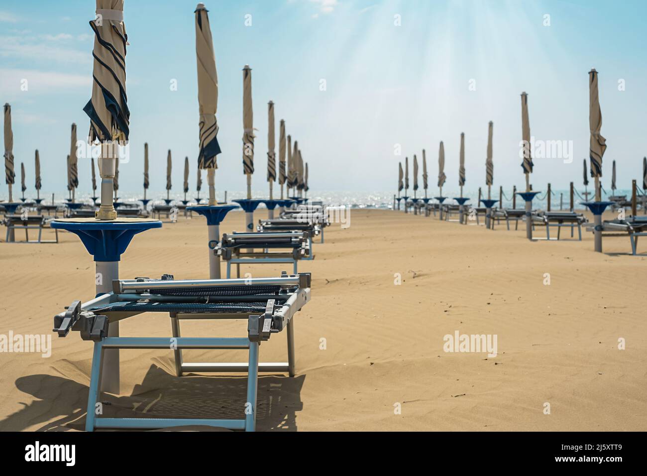 Umbrellas and sunbeds on the beach in Italy. The beach season is ready ...