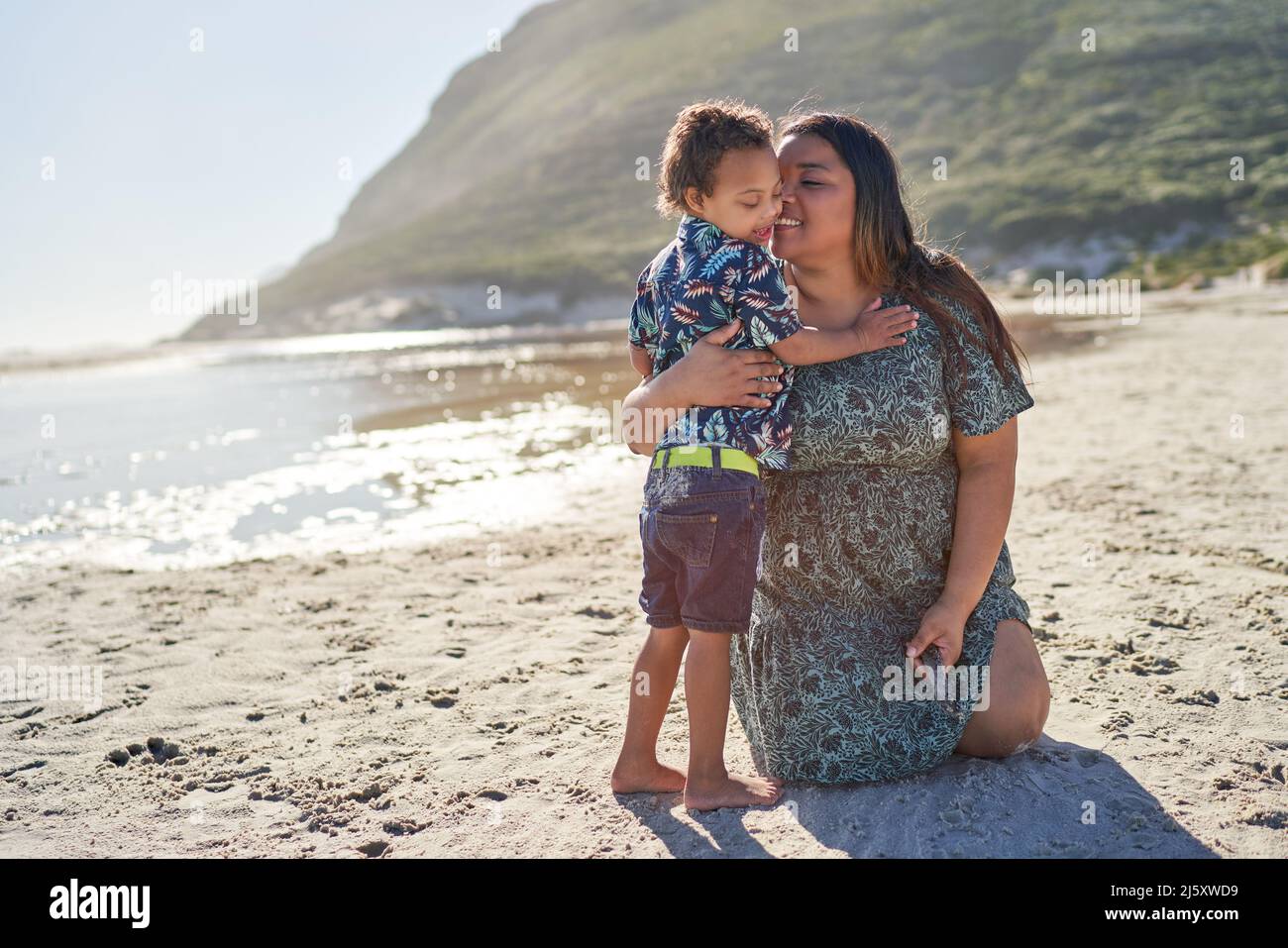 Happy mother hugging cute son on sunny summer beach Stock Photo - Alamy