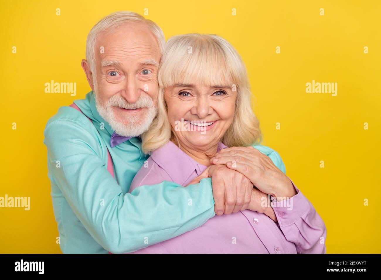 Portrait of two attractive cheerful grey-haired spouses bonding amour ...