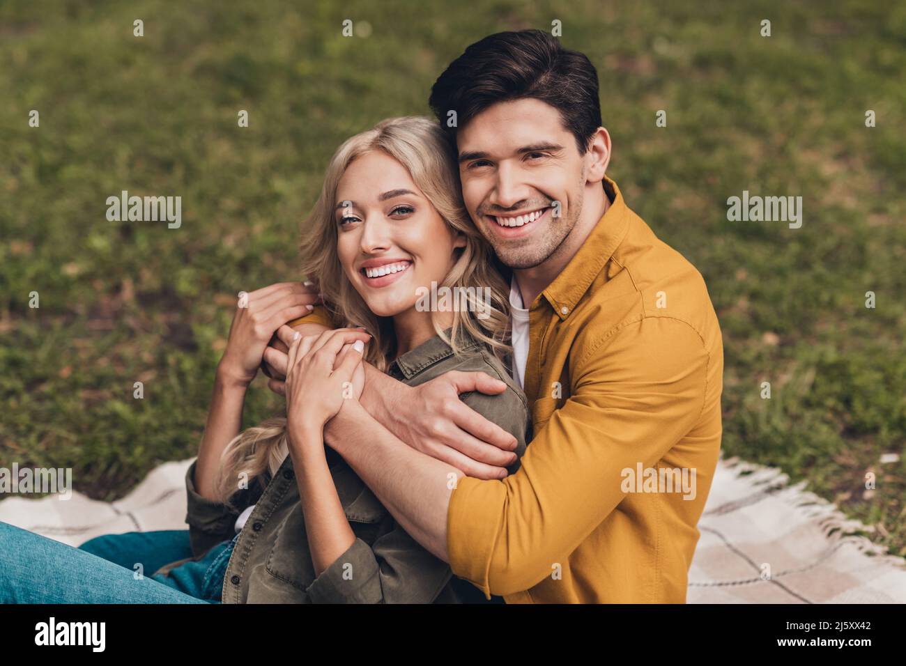 Portrait of amorous adorable cheerful couple spouses hugging sitting ...