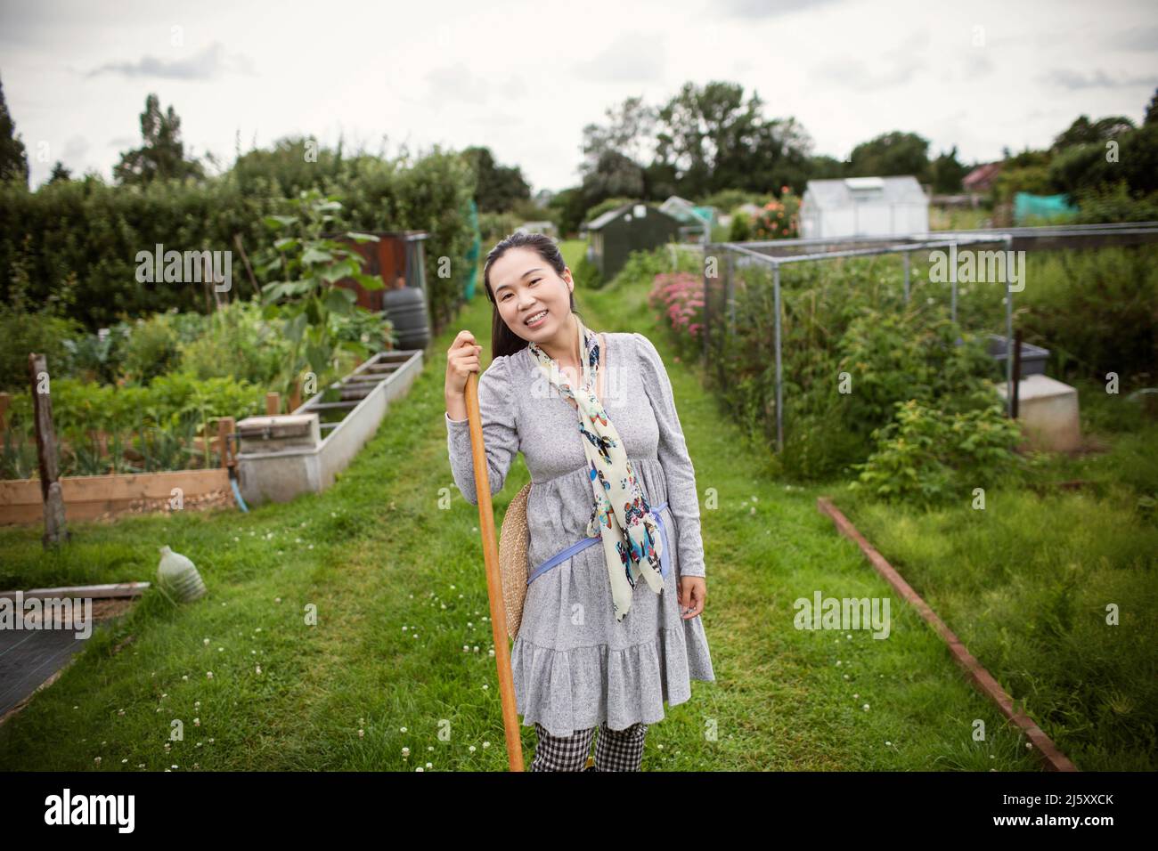 Portrait happy woman gardening in community vegetable garden Stock ...