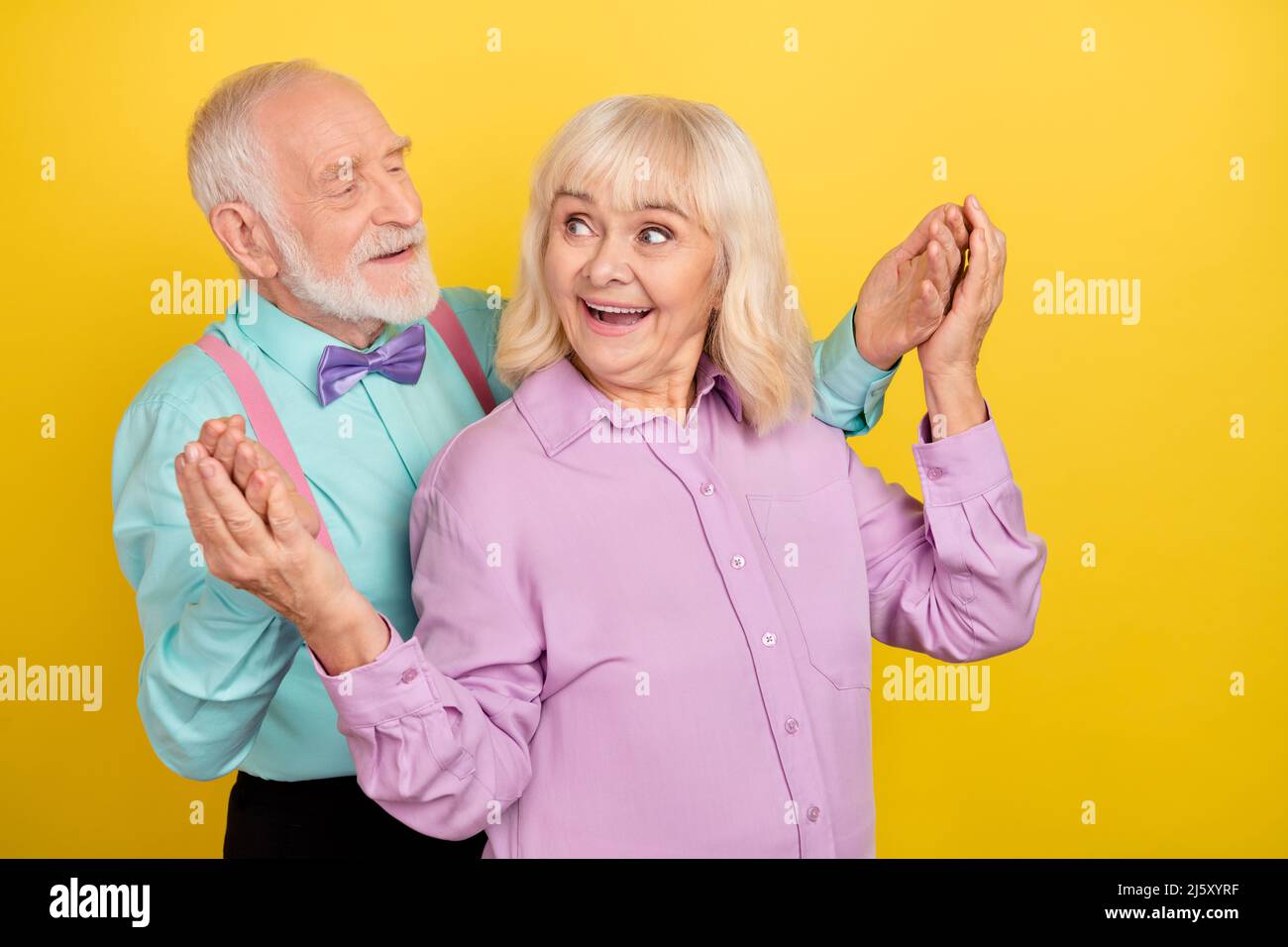 Portrait of two attractive cheerful grey-haired spouses dancing ...