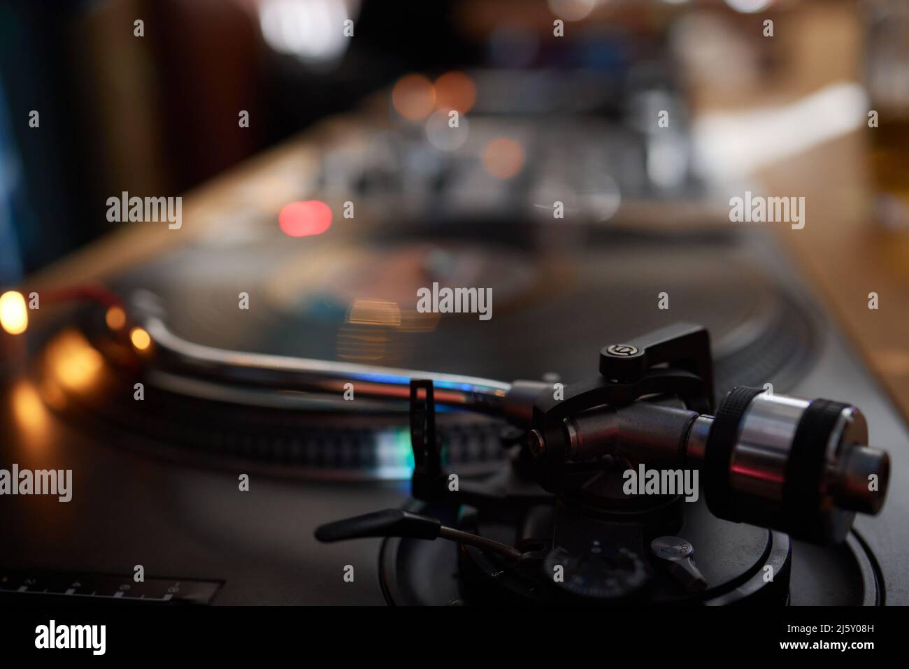 Vinyl record player, bright lights disco-bokeh. Needle on vinyl record ...