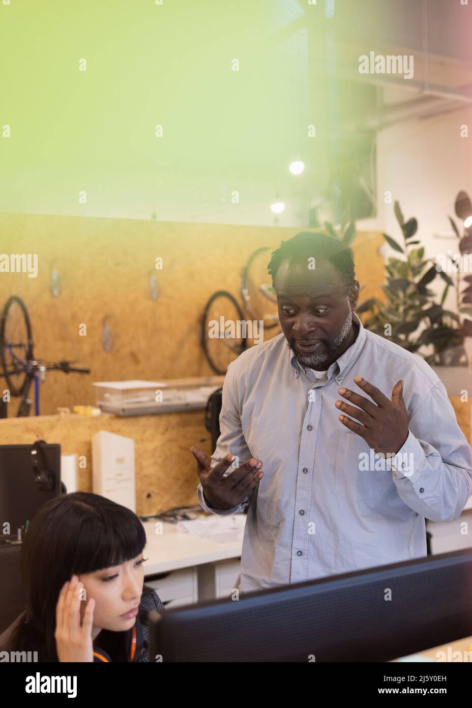 Businessman talking to frustrated businesswoman in office Stock Photo ...