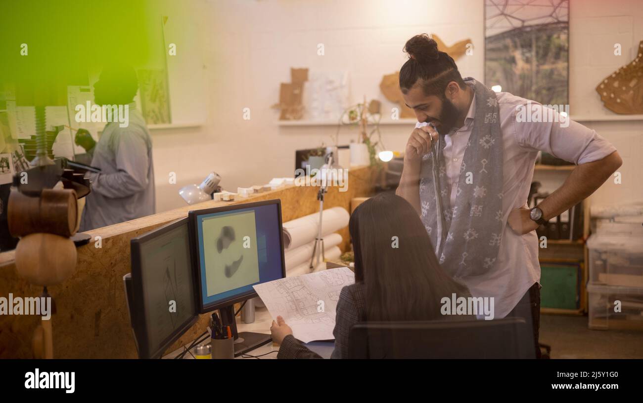 Architects discussing schematics at computer Stock Photo - Alamy