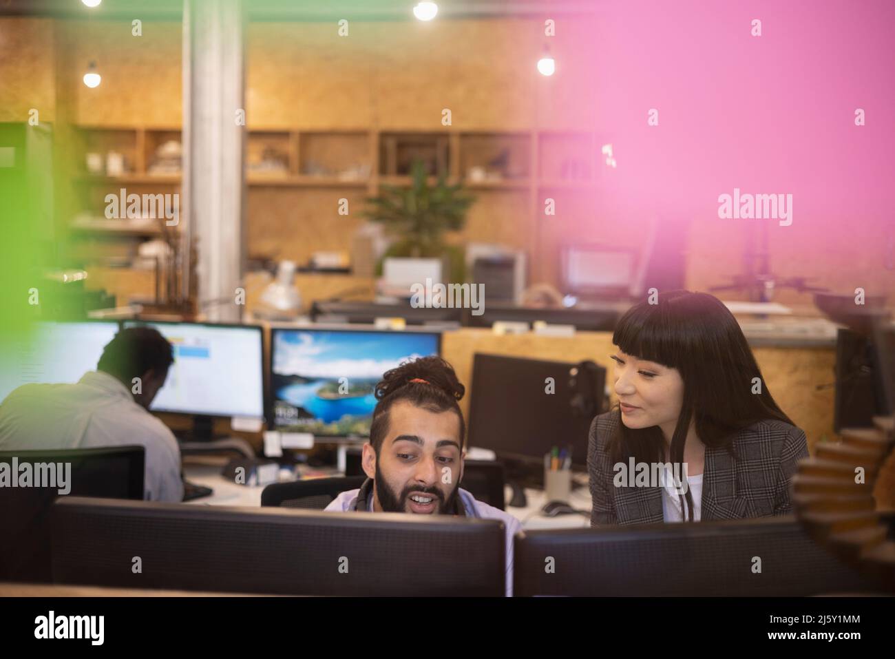 Business people talking at computers in office Stock Photo - Alamy