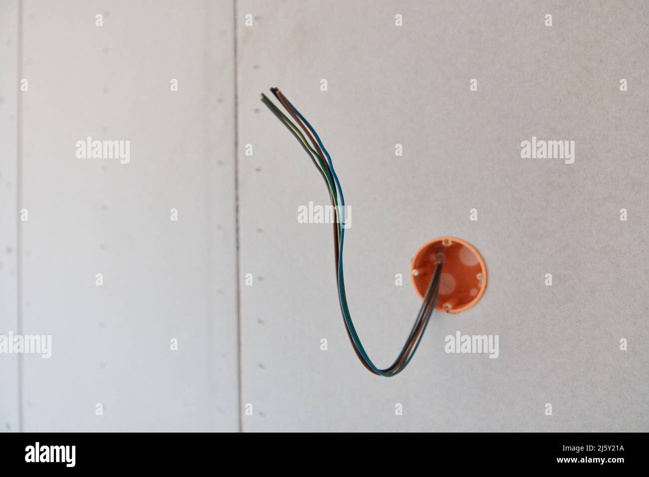 Power cables hang out on the wall in preparation for electrical ...