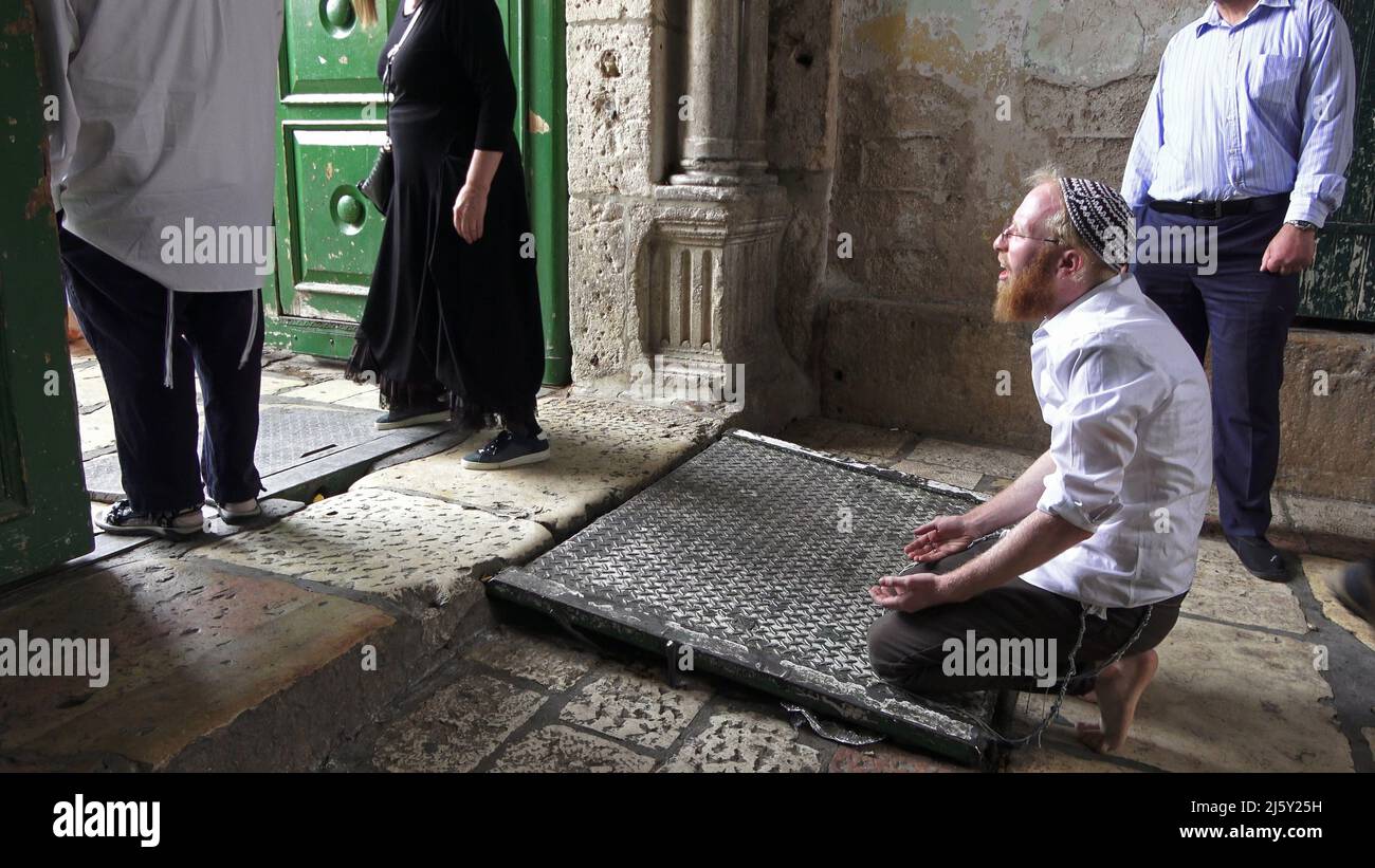 A religious Jew prostrates on the ground in prayer outside the Chain ...