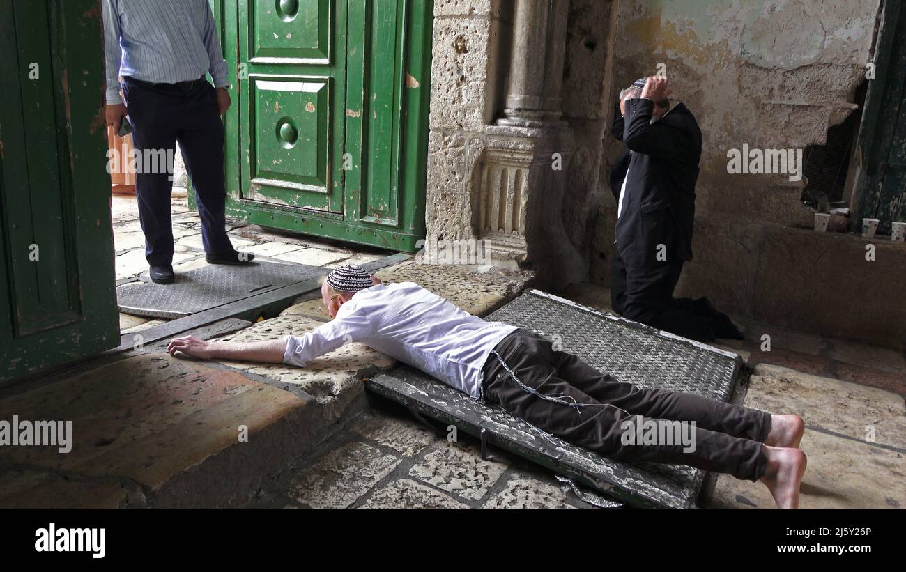 A religious Jew prostrates on the ground in prayer outside the Chain ...