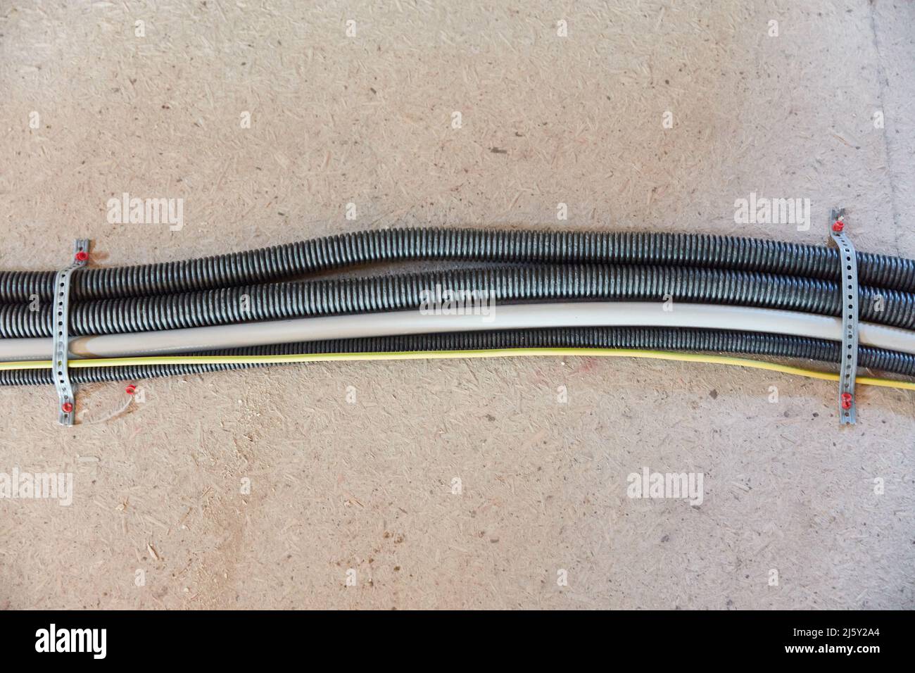 Cables and pipes attached to the ground and laid in a new house Stock ...