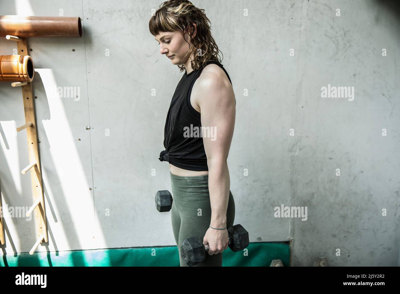 Young woman with dumbbells working out Stock Photo - Alamy
