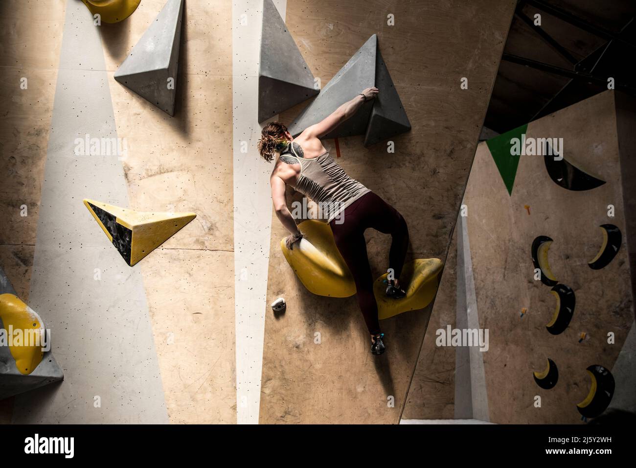 Young woman scaling climbing wall Stock Photo - Alamy
