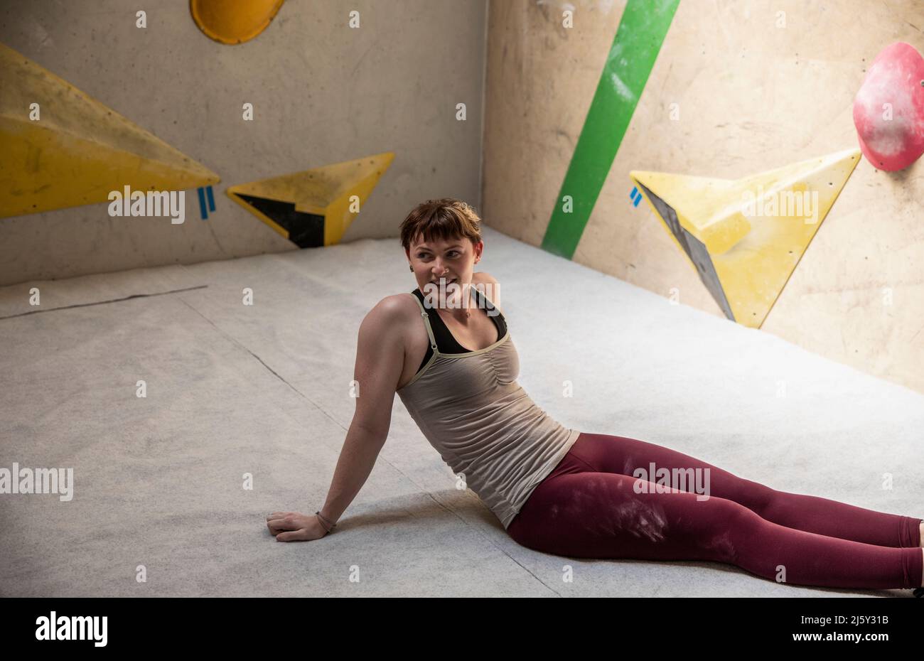 Smiling young female rock climber resting at rock wall Stock Photo - Alamy