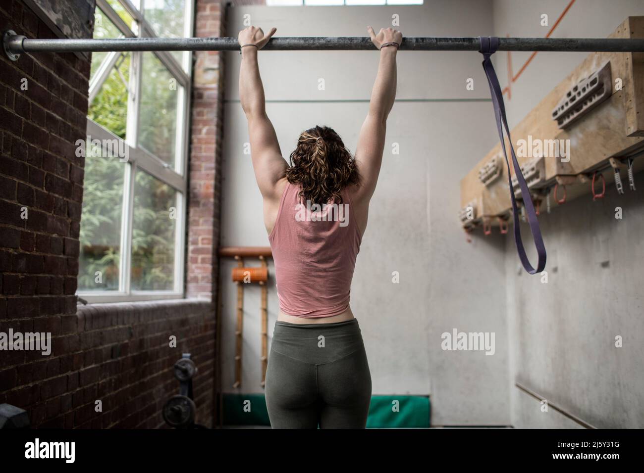 Woman hanging from bar hi-res stock photography and images - Alamy