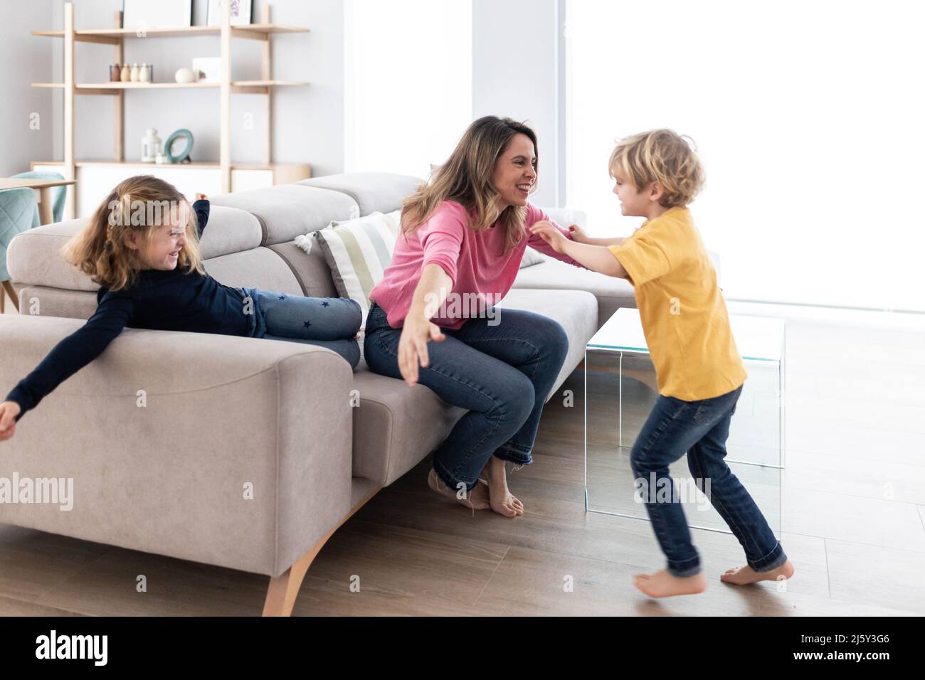 Cheerful mother catching running sin with arms wide open while sitting ...