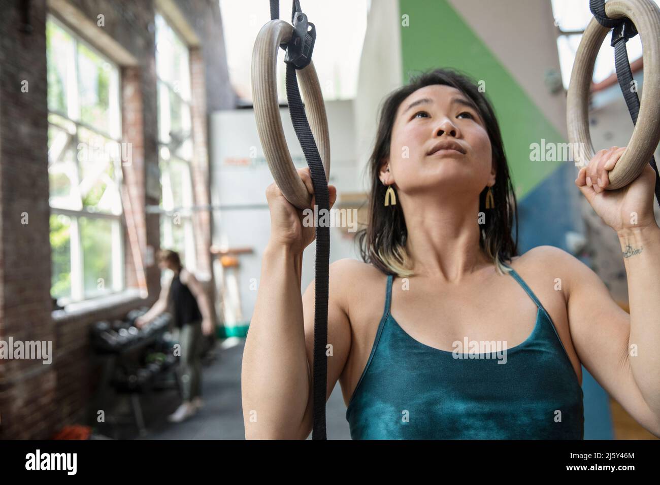 Woman exercising at gymnastics rings in gym Stock Photo - Alamy