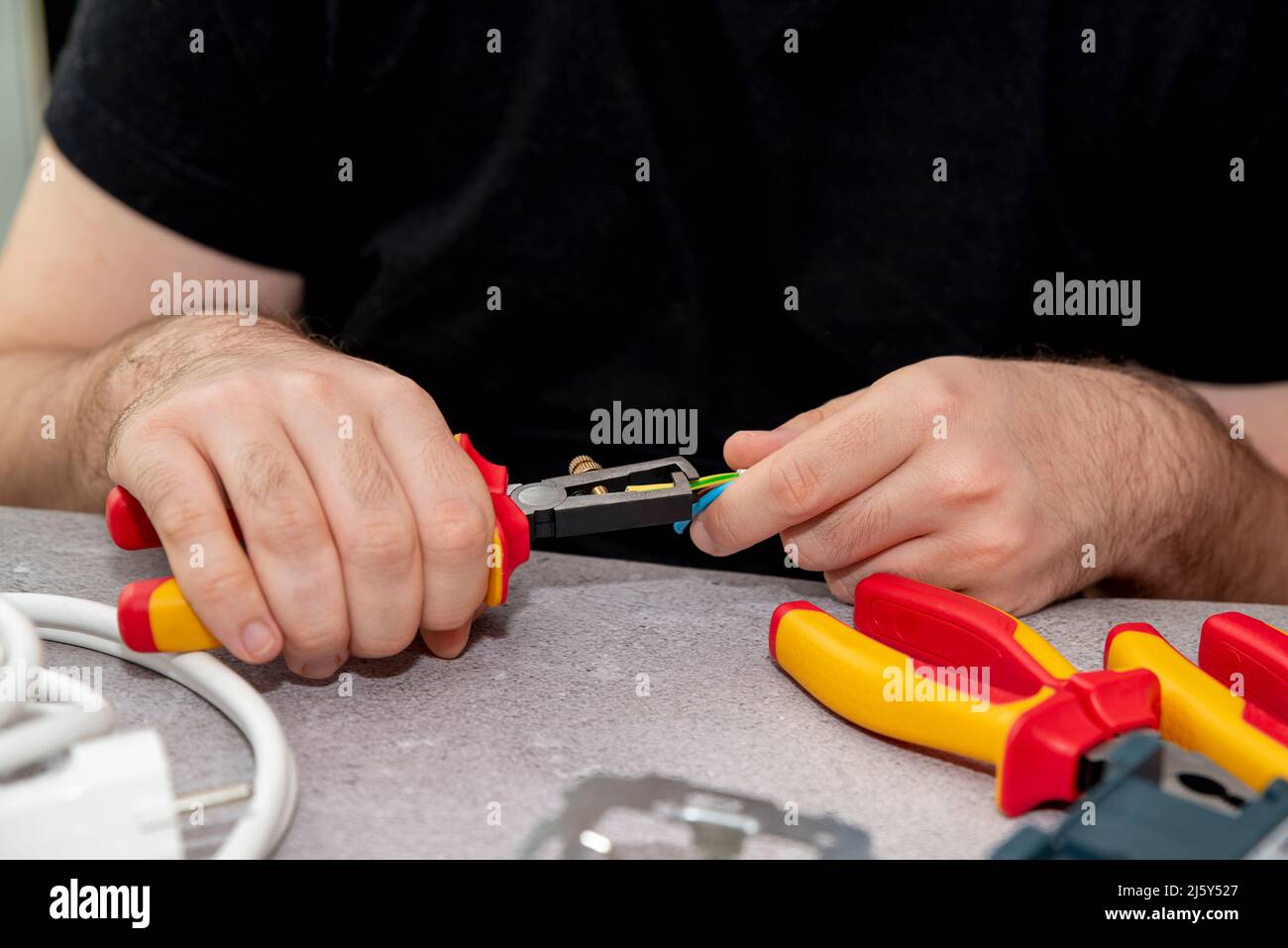 a man holding an electric cutter to strip the insulation from an ...