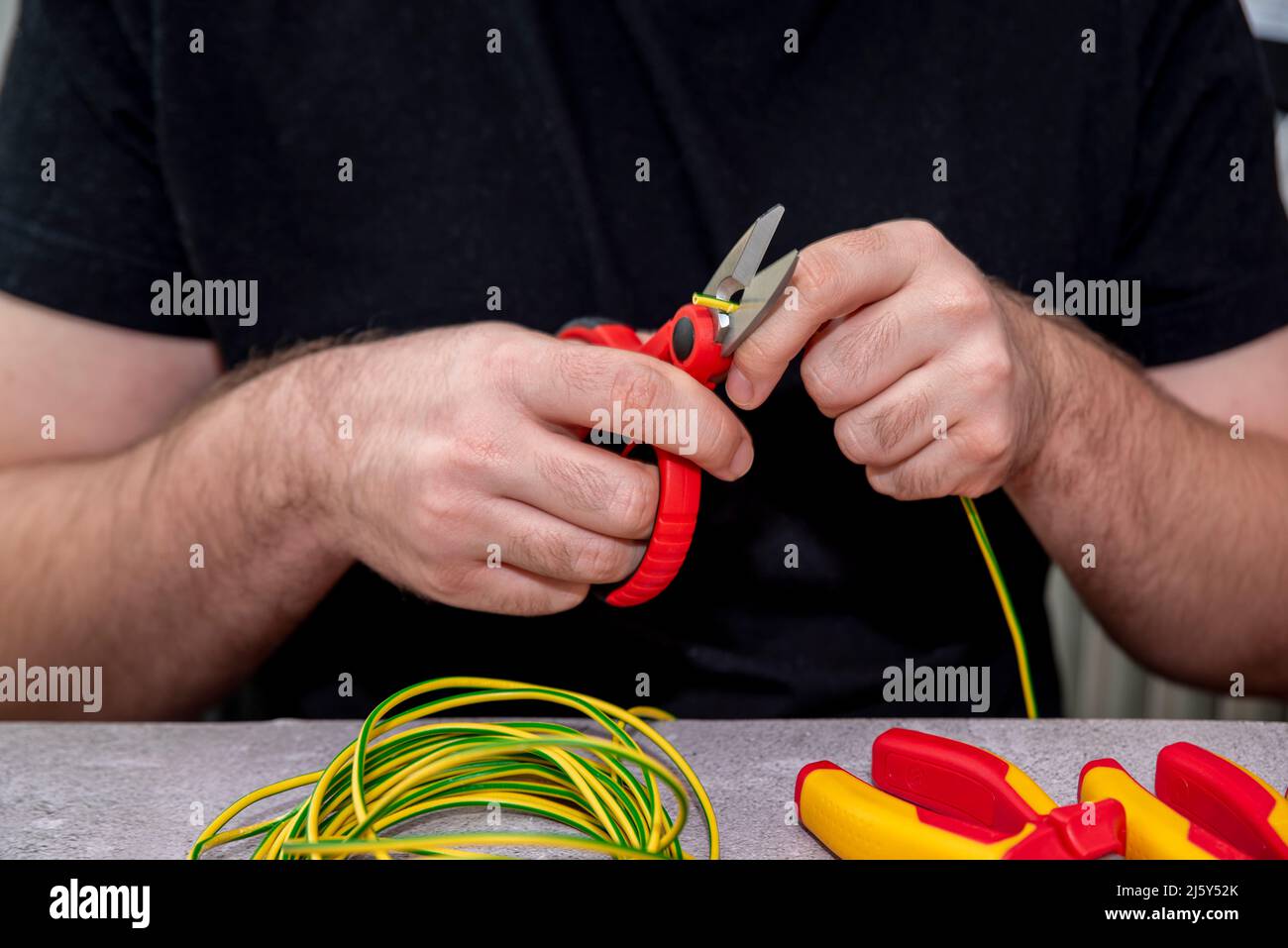 a man holding an electric cutter to strip the insulation from an ...