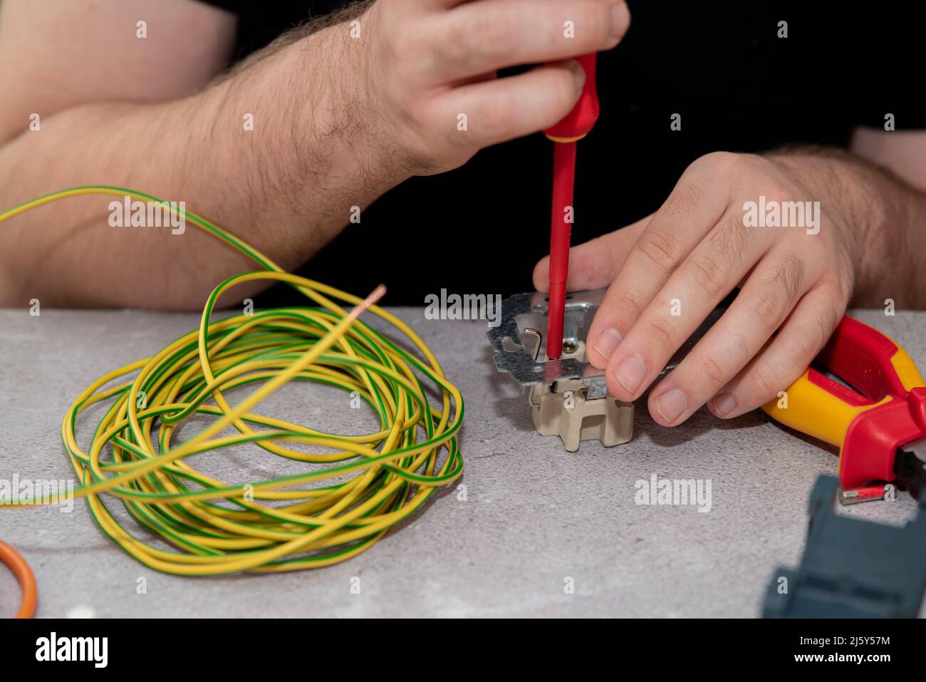 Electrician in his workshop checking that a socket is working properly ...