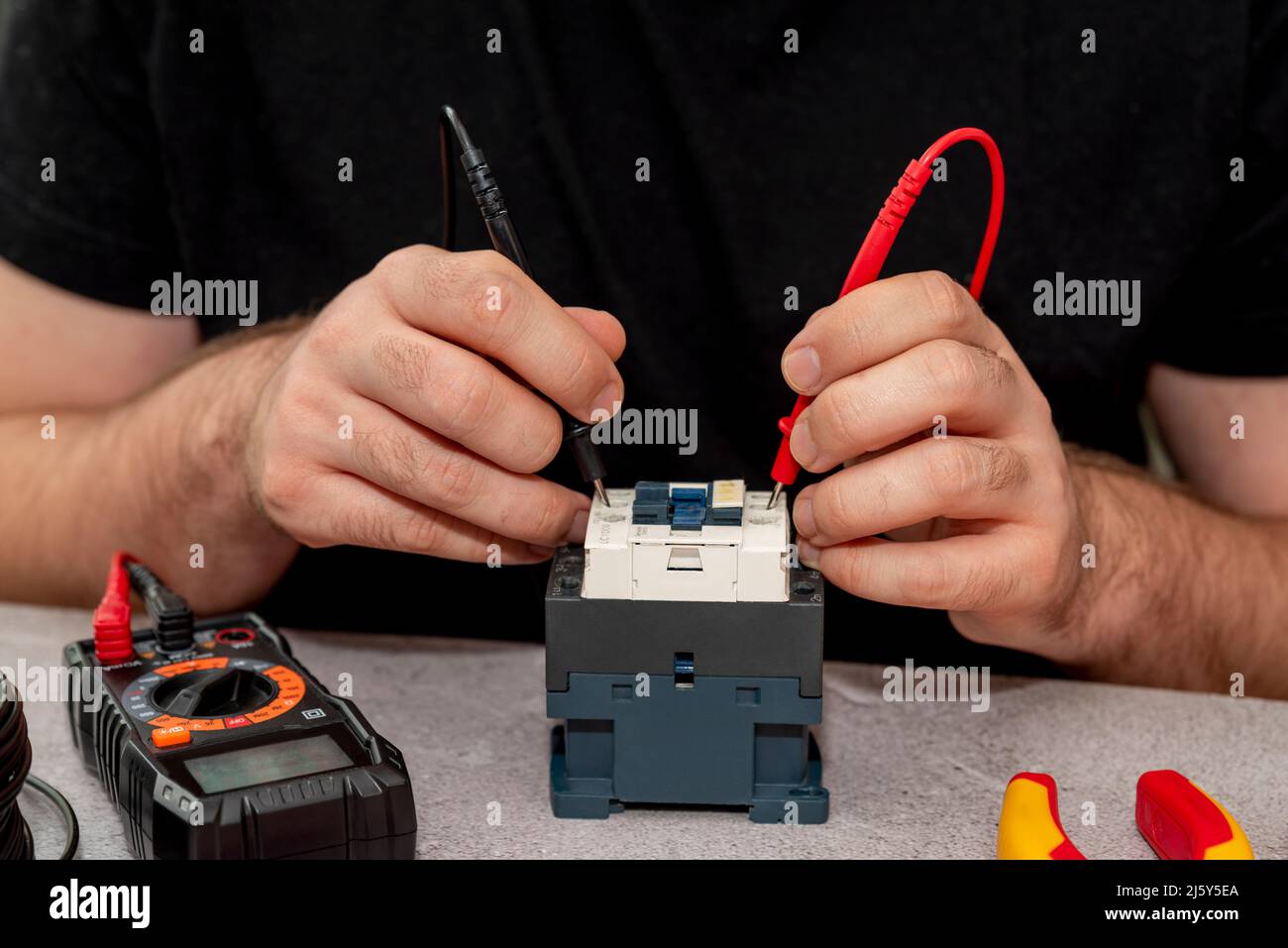 Electrician checking the proper functioning of the switch box with a ...