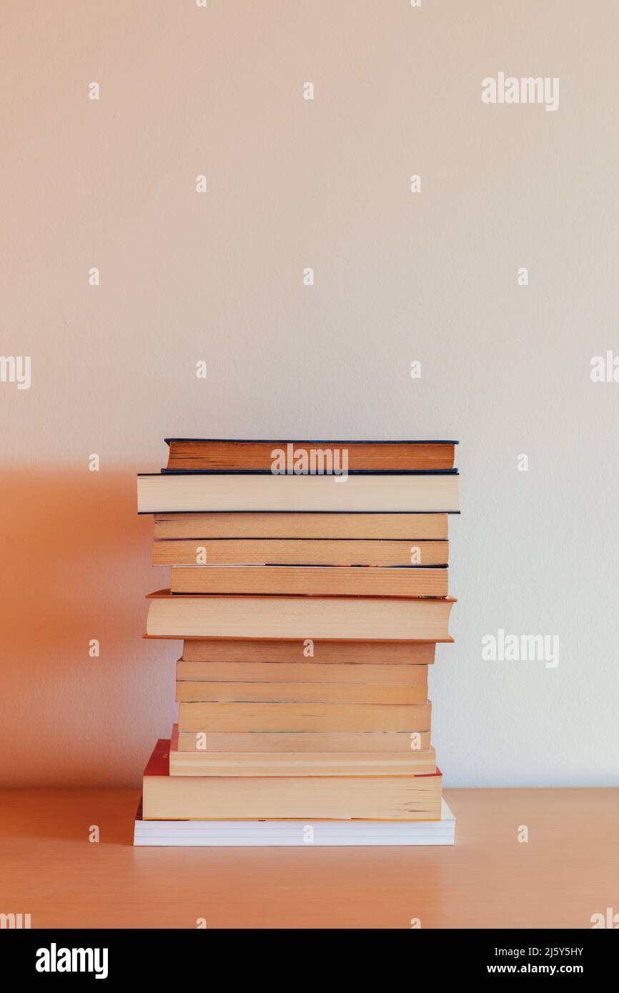 Front view of pile of books on a piece of furniture Stock Photo - Alamy