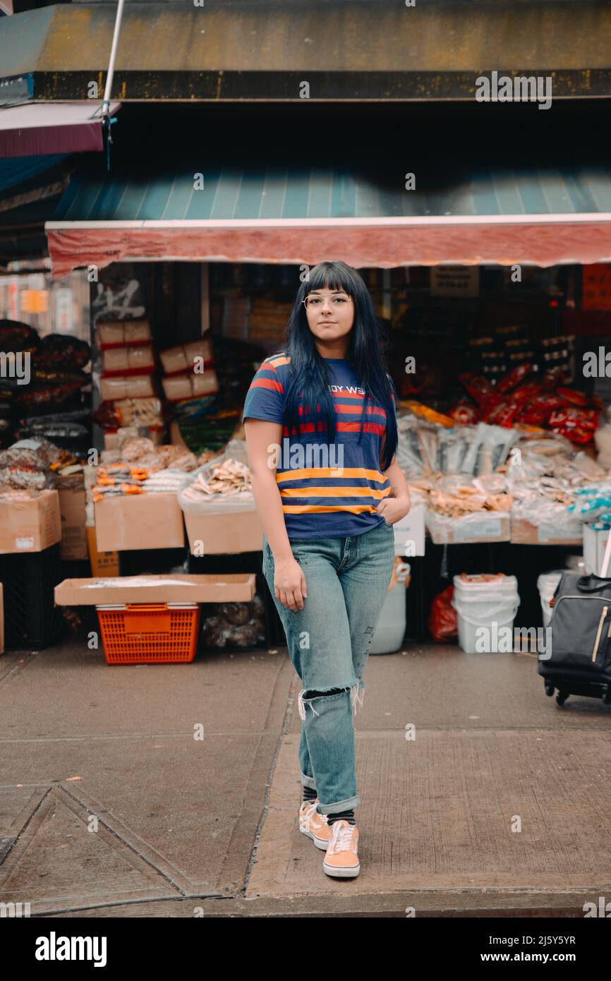 Full body of young female in trendy clothes looking at camera while ...