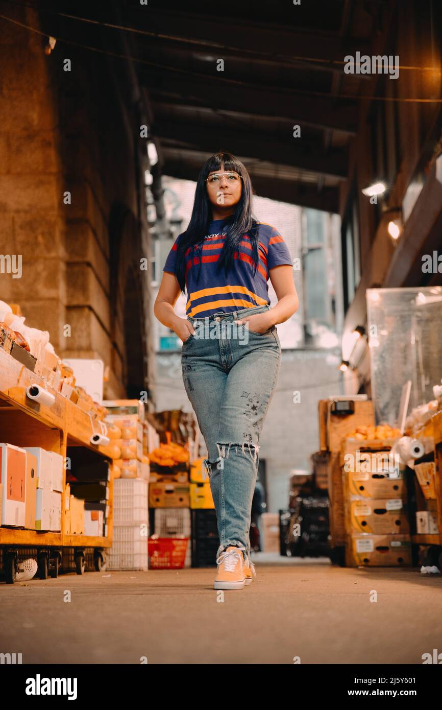 Full body of ethnic female in casual outfit looking into distance while ...